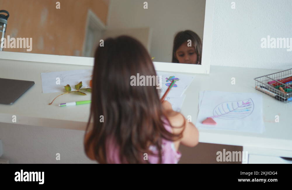Little girl coloring different types of leaves on a paper sheet with a ...