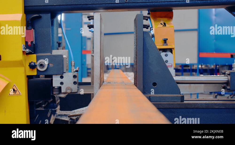 Industrial machinery, a metal cutting machine is cutting a long metal ...