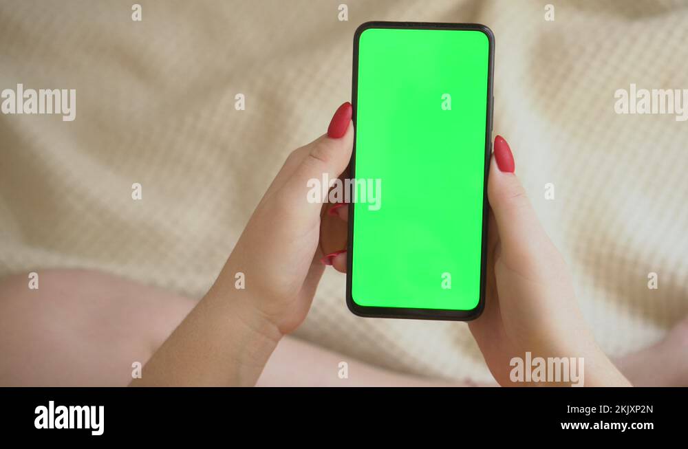 Back view over shoulder of young girl using smartphone with green ...