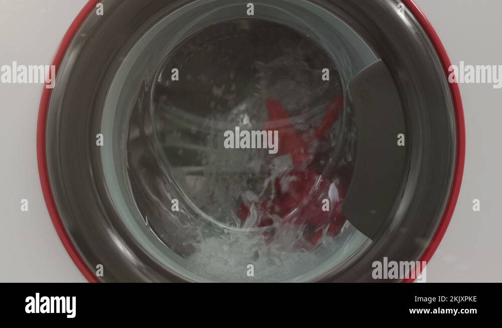 Close up view porthole of washing machine. Washing clothes process in ...