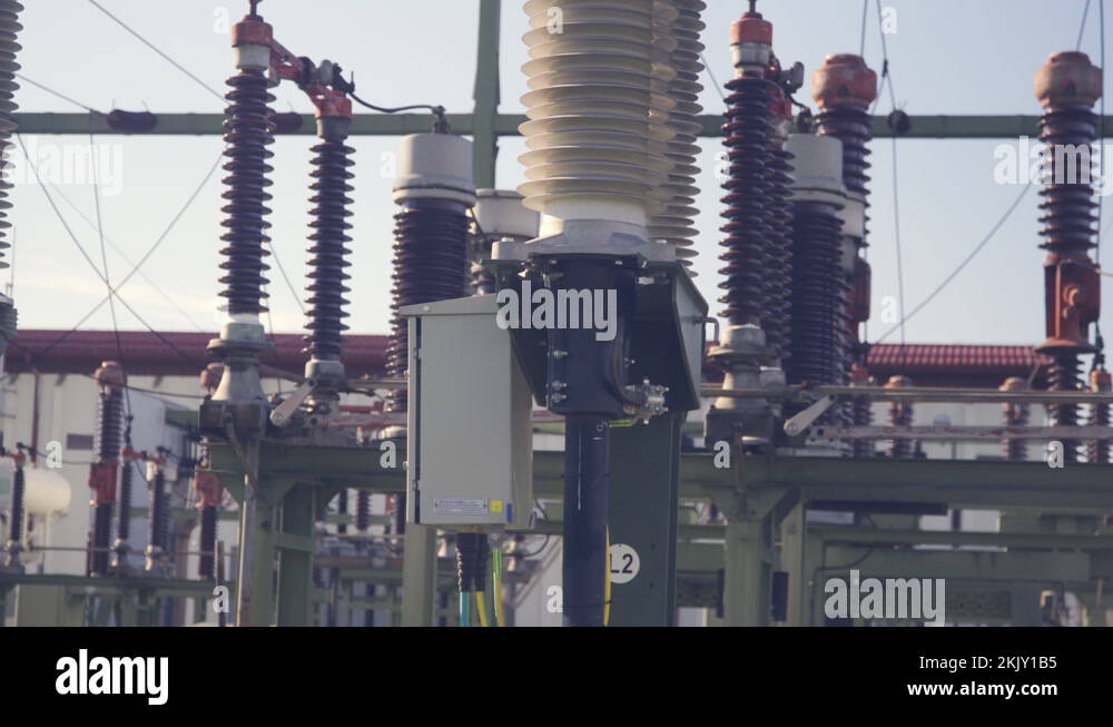 Close up, high voltage substation with tall pylons and voltage ...