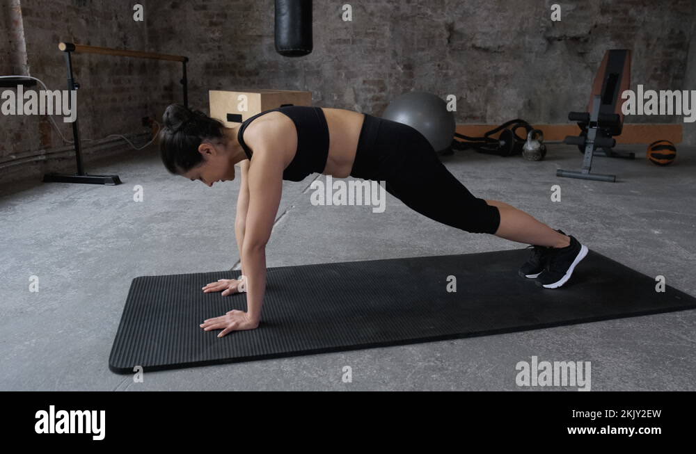 Young amazing fitness woman make plank exercise in gym. A Young Indian ...