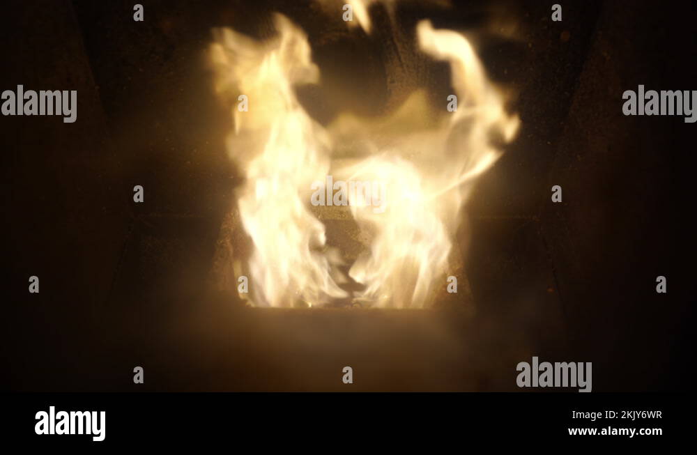 Powerful fire flames going out of pellet stove cylinder and burning ...