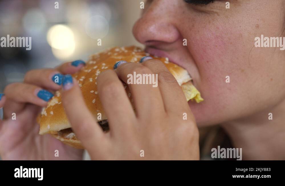 Young Hungry Woman Biting Vegan Meatless Burger in Fast Food Restaurant ...