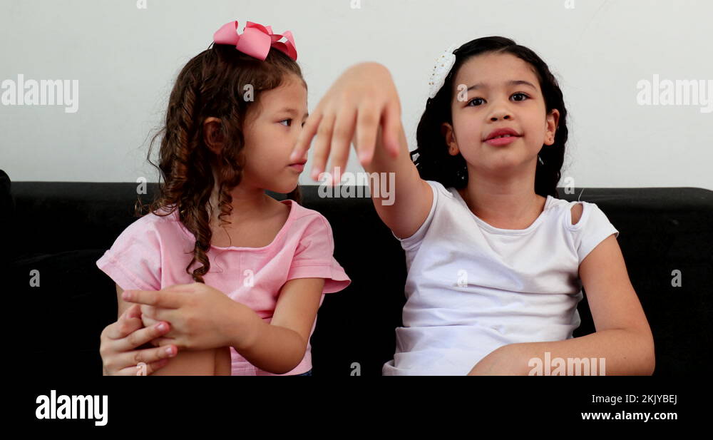 Two little girl speaking to camera in video conference. small sisters ...