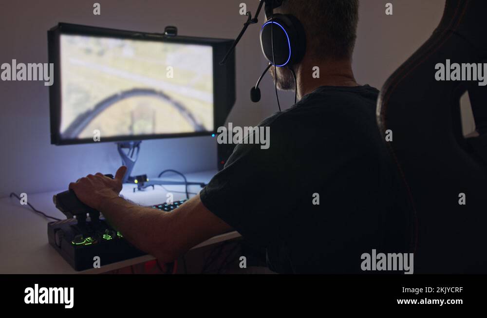 Man playing a flight simulator on the computer, wearing a headset Stock ...