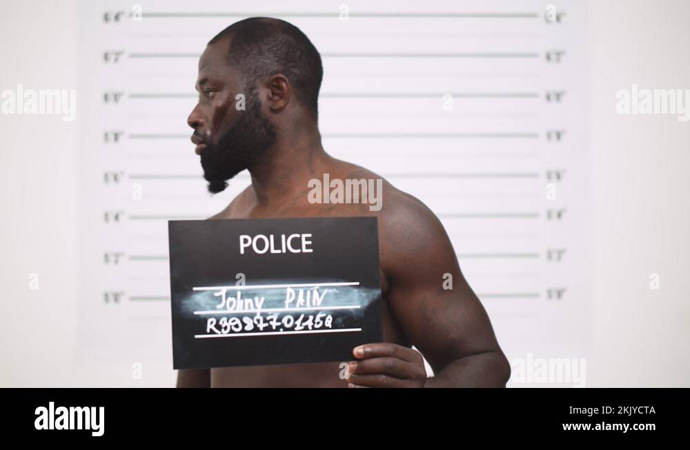 In a police station african arrested beaten man poses for front view ...