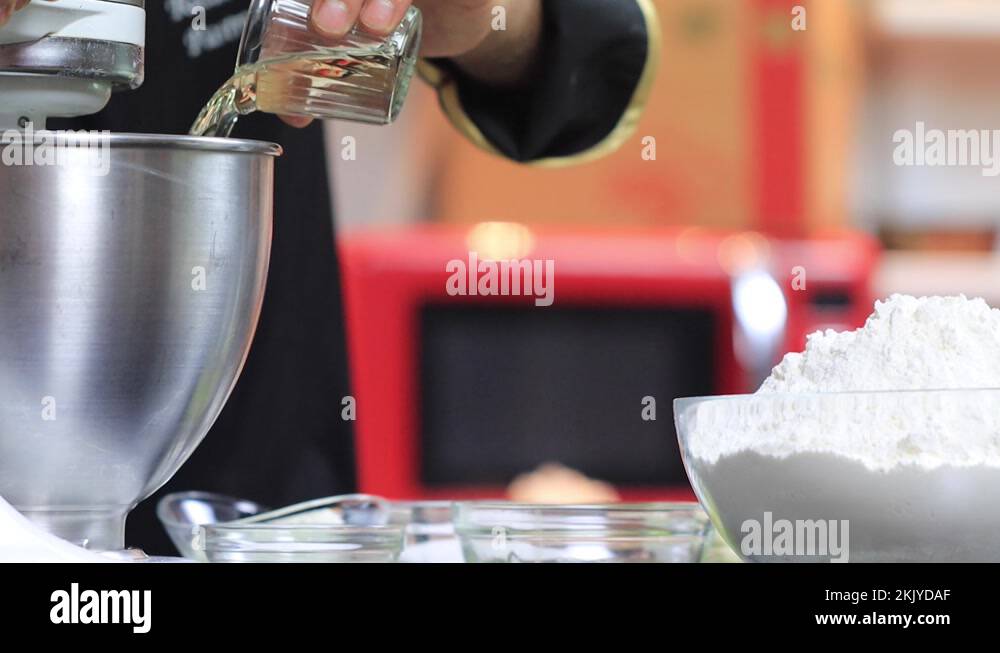 Chef is mixing ingredients with electric mixer in bowl. Preparing cake ...