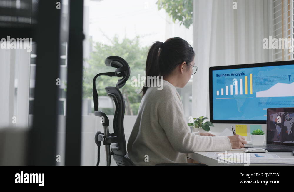 Wide shot of young attractive asian woman busy work multiple screen ...
