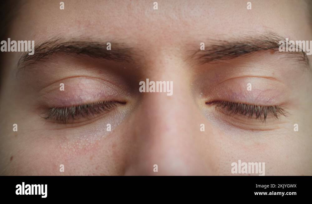 Close up of Man's face. Attractive boy with blue eyes raising eyebrows ...