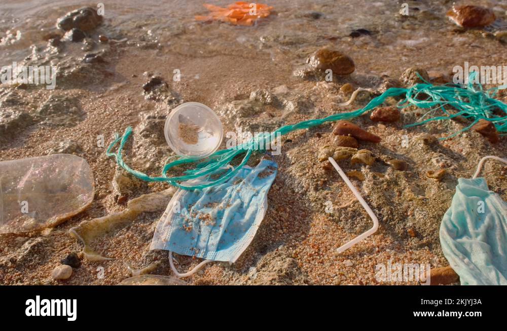 Disposable face masks and plastic debris on the beach in surf zone ...