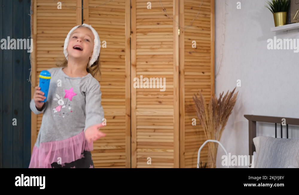 Little Girl Singing and Dancing on Bed at Home Stock Video Footage - Alamy