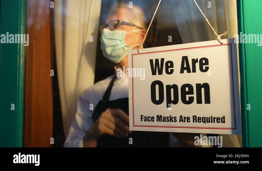 Business owner attractive chef woman in apron hanging face masks ...