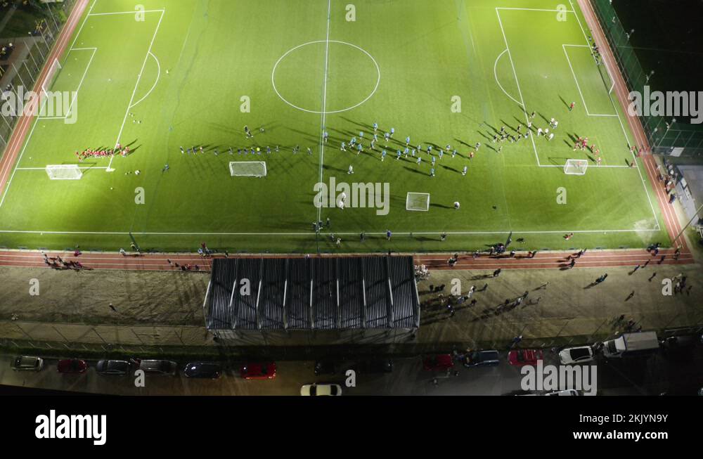 Aerial night shot of a neighbourhood football field. Teams playing and ...