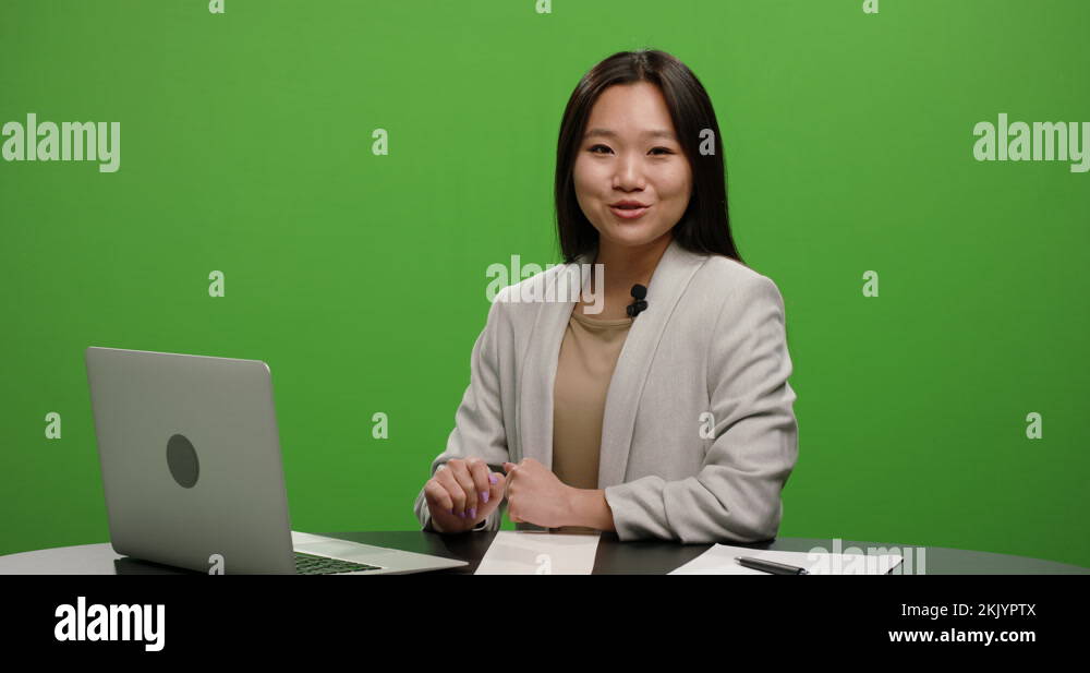 Asian female news reporter talking about current events, looking into ...