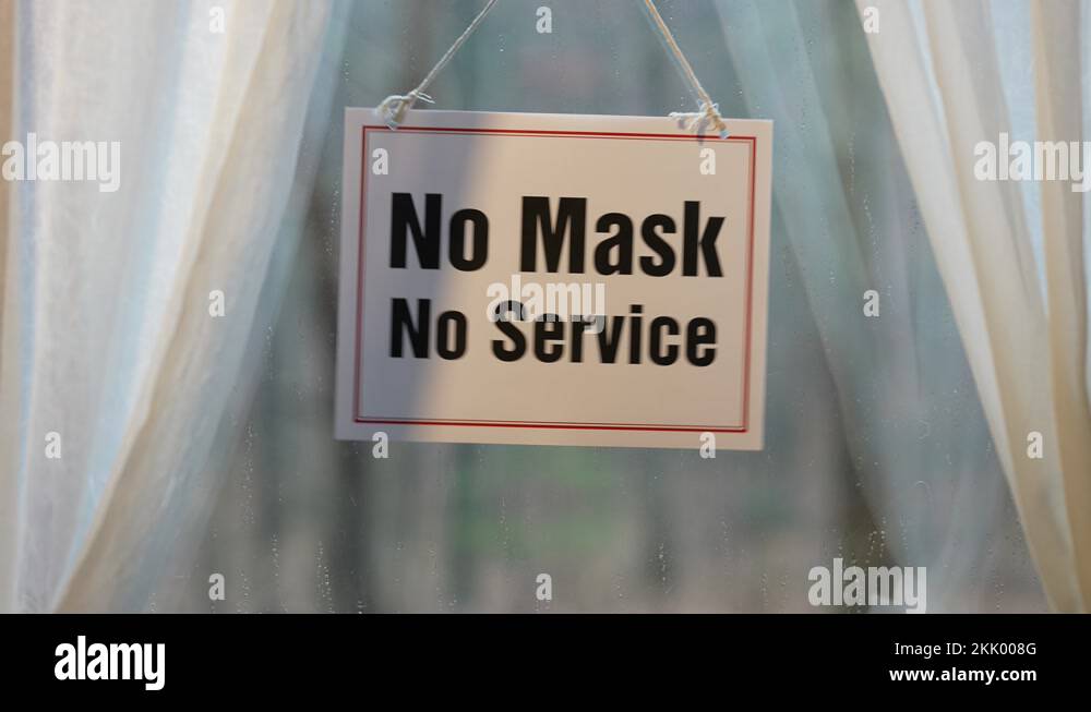 No Mask No Service sign swinging in the window of store front display ...