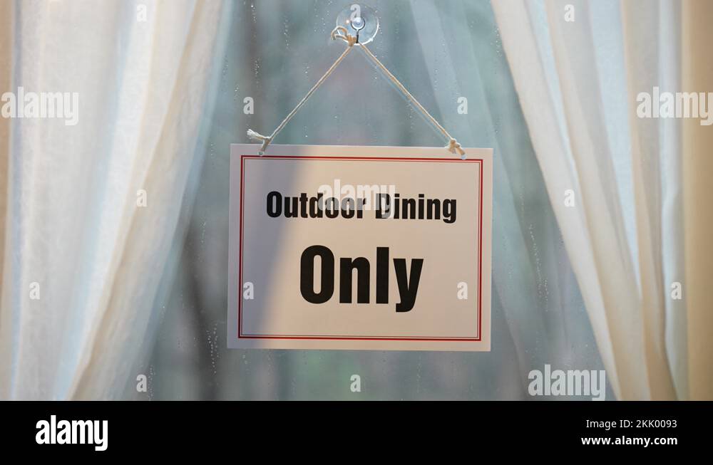 Outdoor Dining Only sign hanging in the window of store front display ...