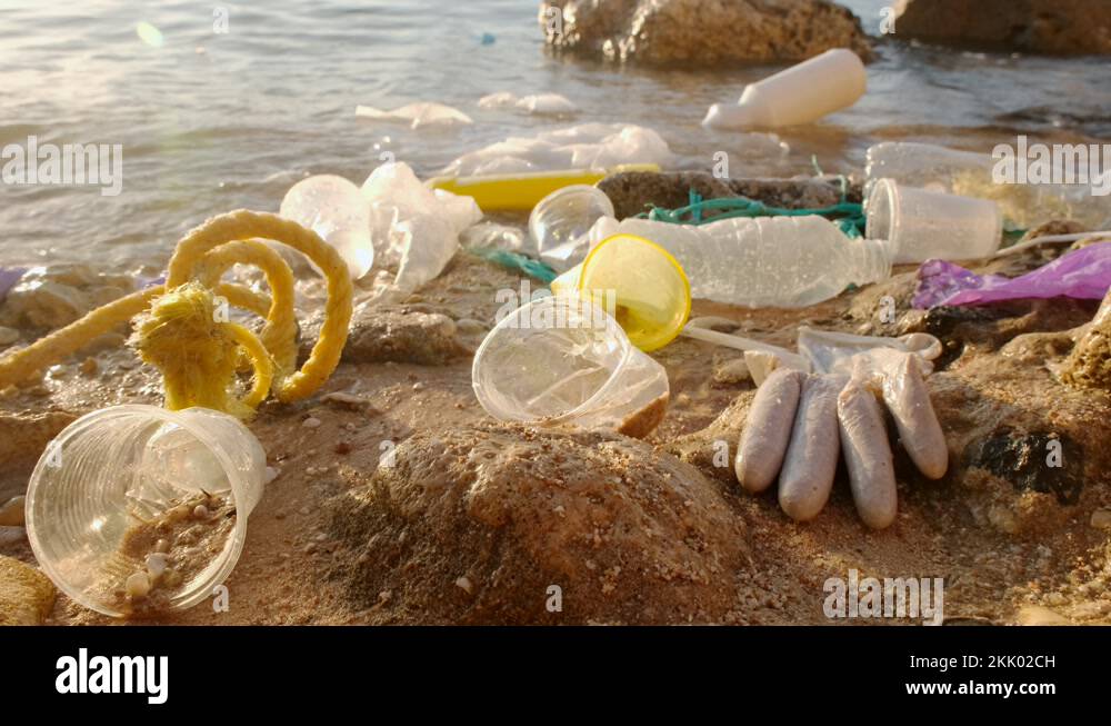 Disposable face masks and plastic debris on the beach in surf zone ...
