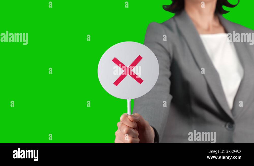 Woman showing a cross sign plate. Green background for chroma key ...