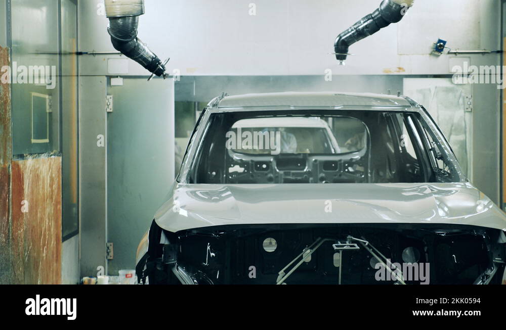 Robotic arms spray painting a vehicle body at car manufacturing ...