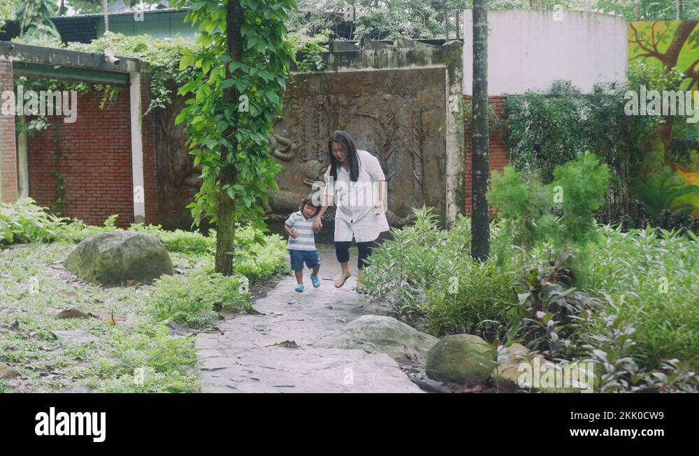 A mother a son walking at the zoo with an angry son wanting to be ...