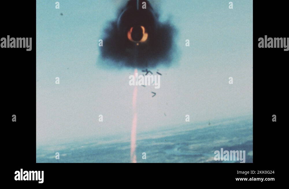 1960s: Fighter jet fires ammunition. Explosions on ground. Plane drops ...