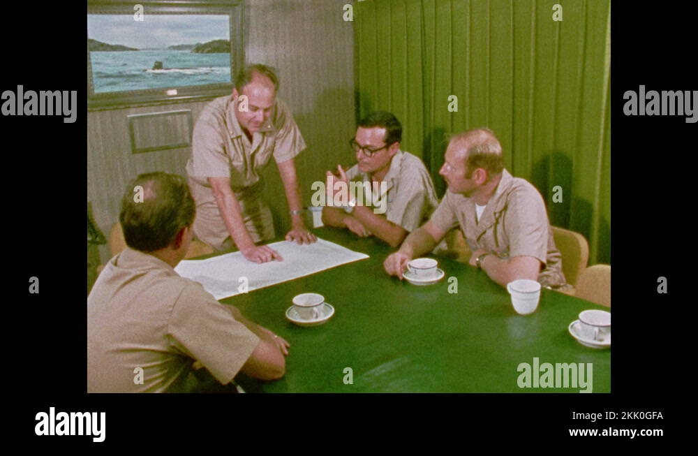 1970s: men mapping out route and information, man sitting in chair in ...