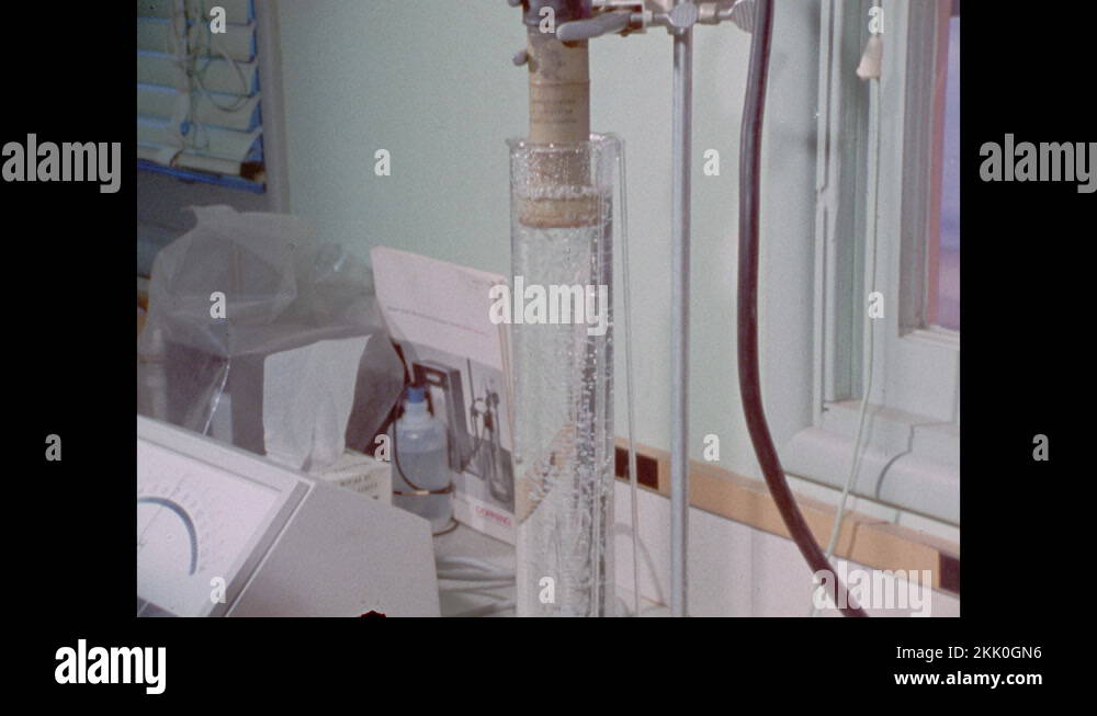1970s: Bubbles in cylinder. Man performs experiment in lab. Building ...