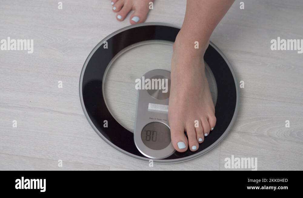 women's legs stand on electric scales and on the scoreboard weights ...