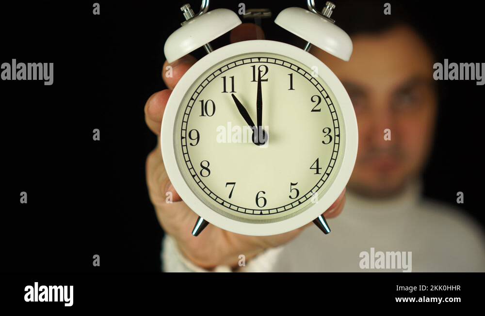 11 o'clock. Human hand holding alarm clock that showing eleven o'clock ...