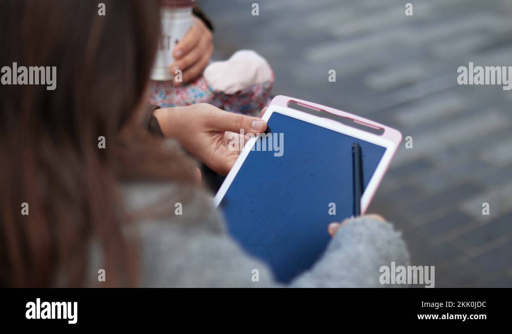Concentrated little girl drawing stick figures on a tablet Stock Video ...