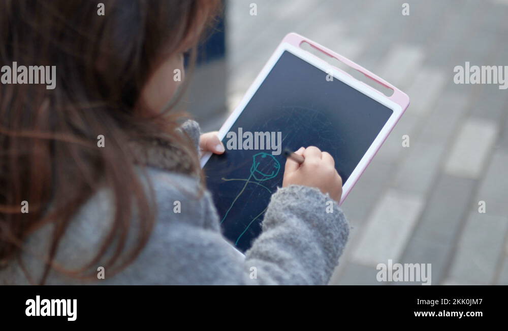 Concentrated little girl drawing stick figures on a tablet Stock Video ...