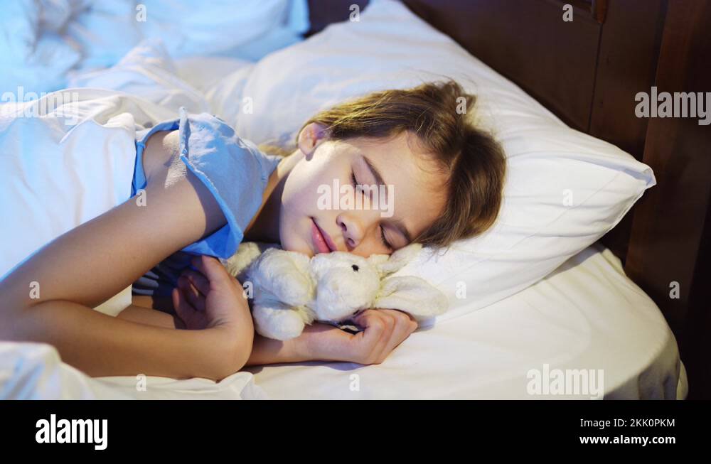 The pretty teenage girl naps with a plush toy, sees a pleasant sleep ...