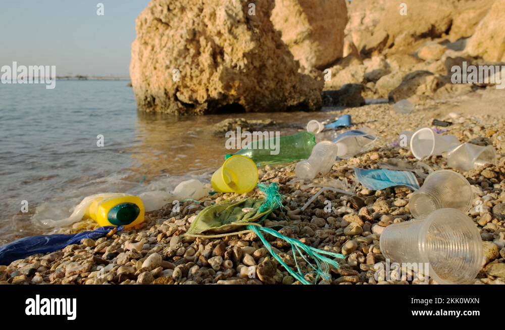 Disposable face masks and plastic debris on the beach in surf zone ...
