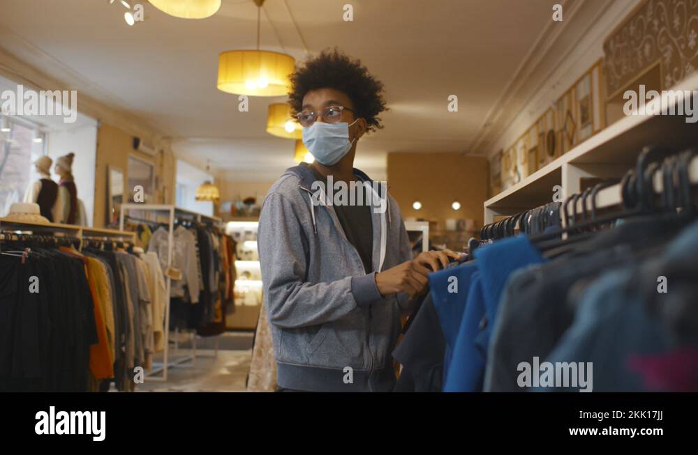African young man stealing jeans while being in clothes shop Stock ...