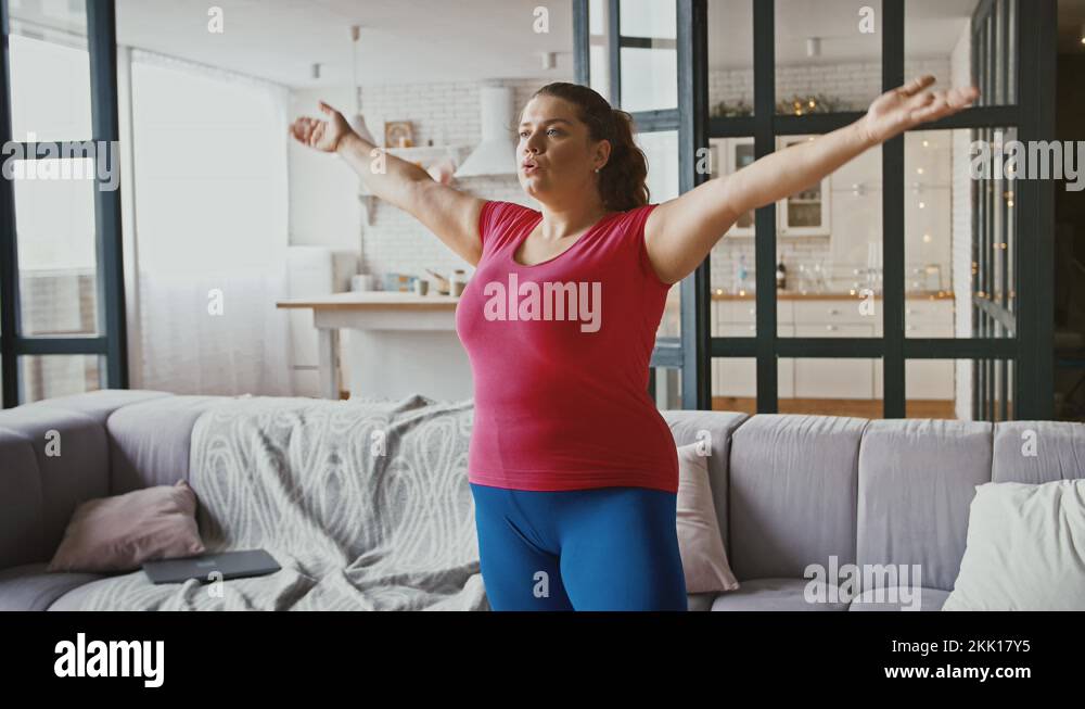 Breathing exercise. Young overweight lady practicing yoga tree pose at ...