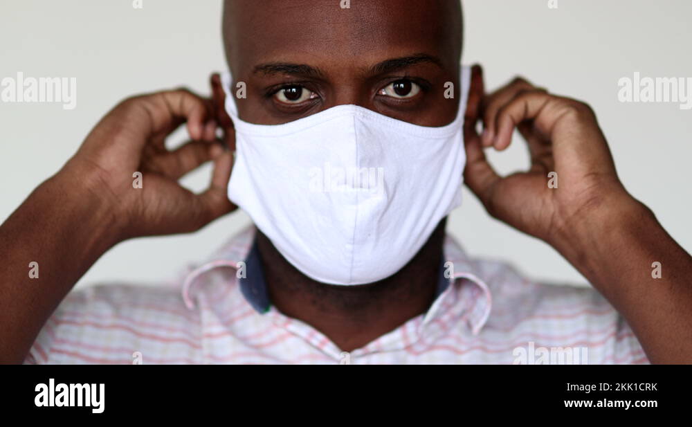 African man covering face with mask to protect from bacteria and ...