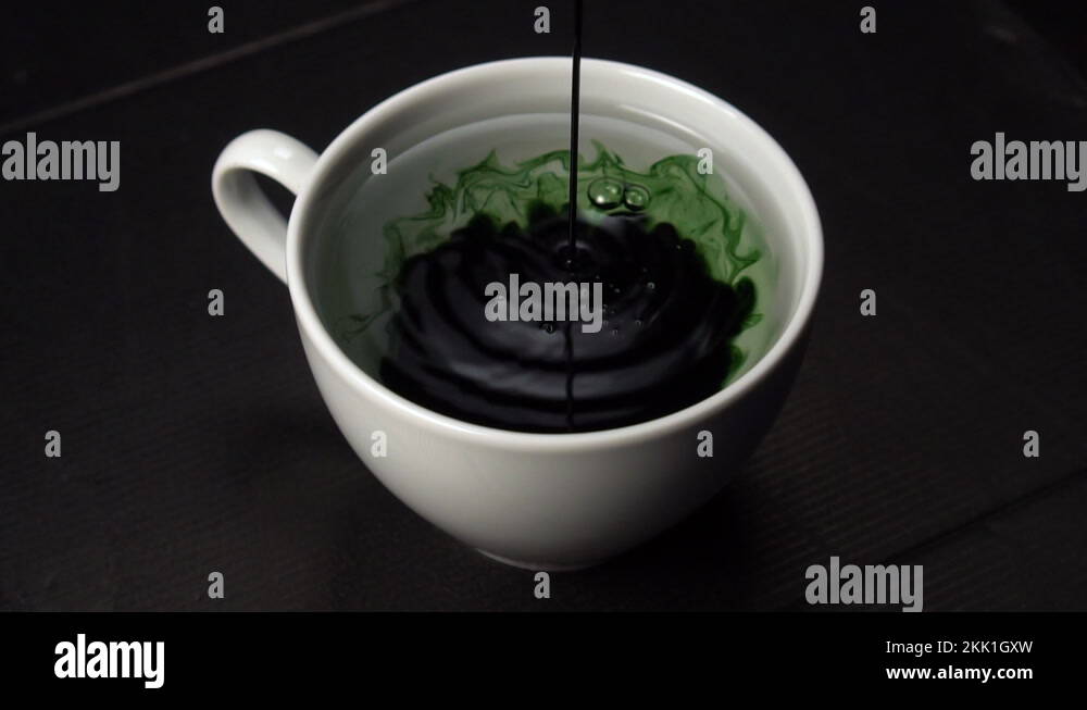Chlorophyll extract is poured and mixed with pure water in a white cup ...