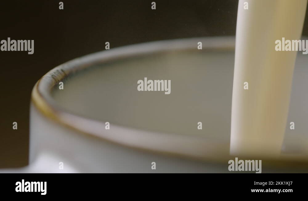 ZOOM IN frothy milk is poured into a cup to make a cappuccino, 60fps ...