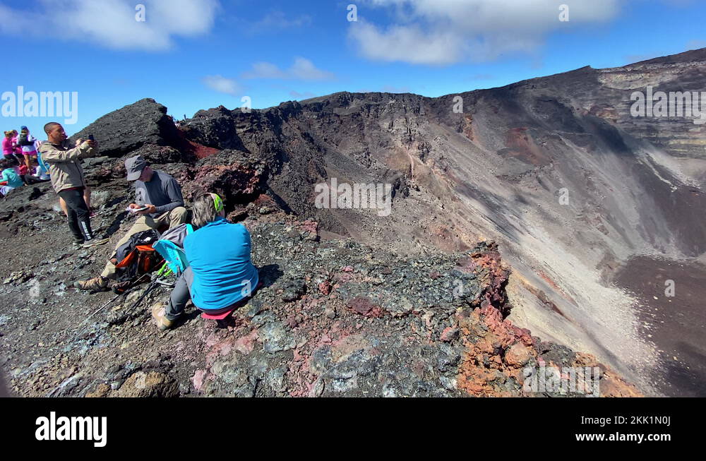 Hikers having a rest at the top of the volcano Piton de la Fournaise on ...