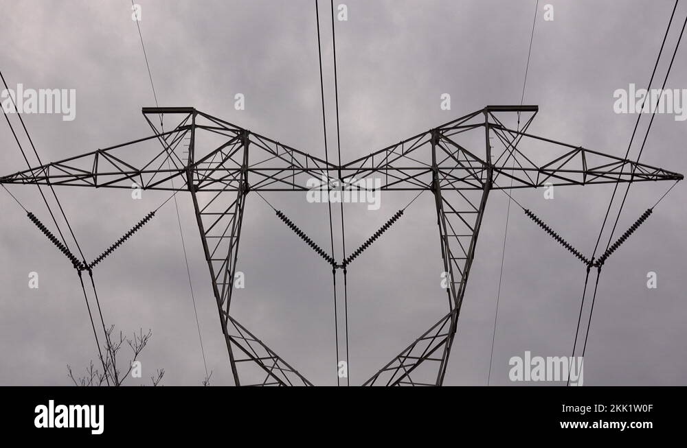 Top part of electrical pylon with insulators and high tension lines ...
