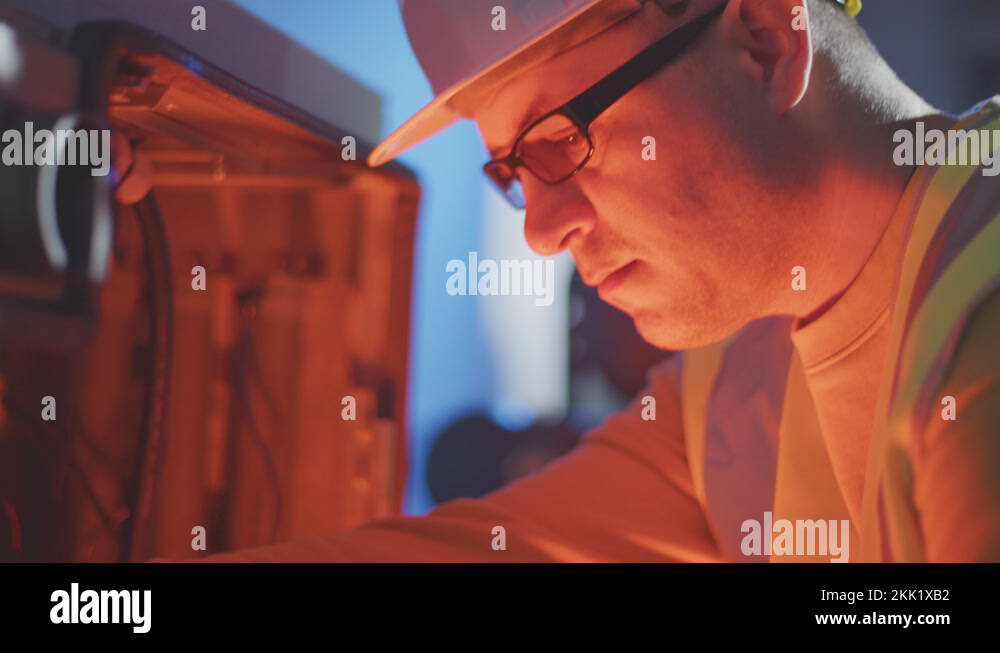 Engineer or electrician works with broken industrial robot cabinet ...