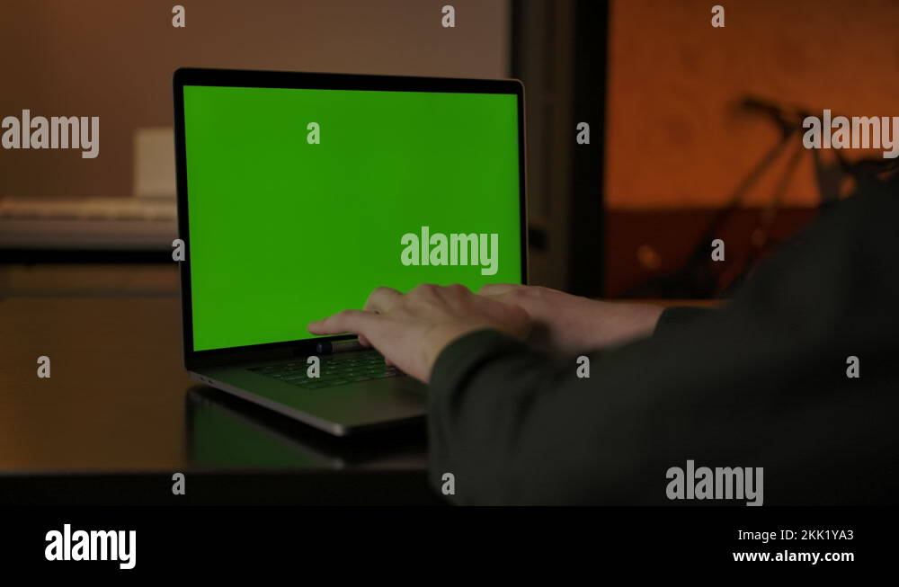 Faceless male typing something on green screen laptop keyboard Stock ...