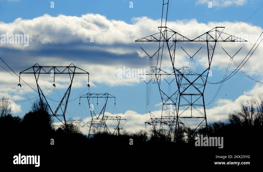 Electrical towers and swaying transmission lines with clouds moving in ...