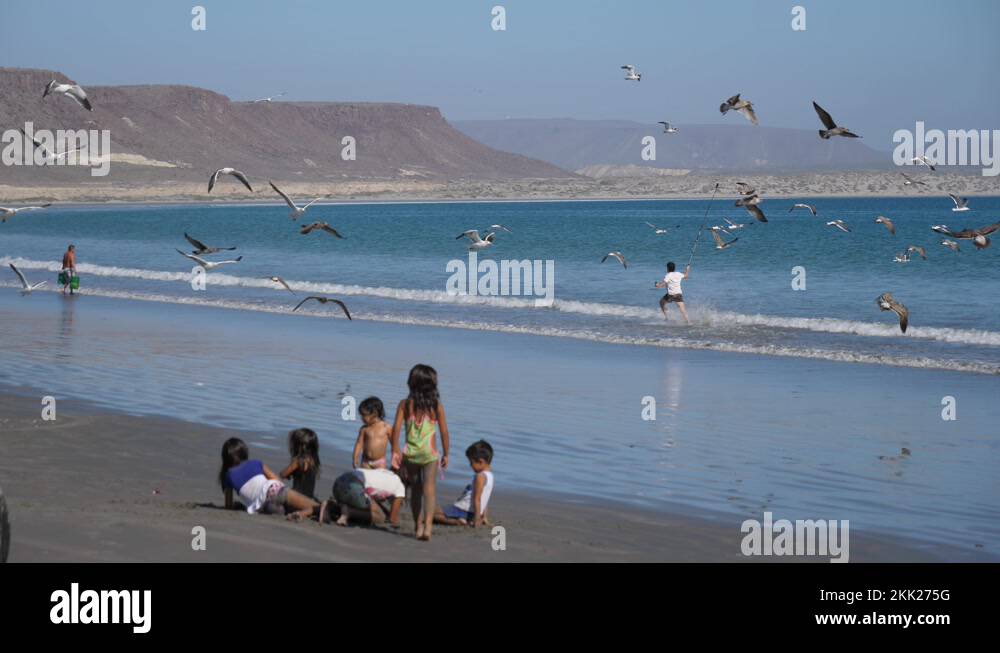 Establishing shot, Children playing on the beach of San Juanico Stock ...
