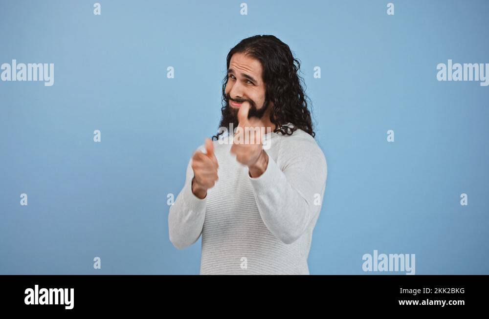 Playful italian guy pointing fingers to camera, winking and smiling ...