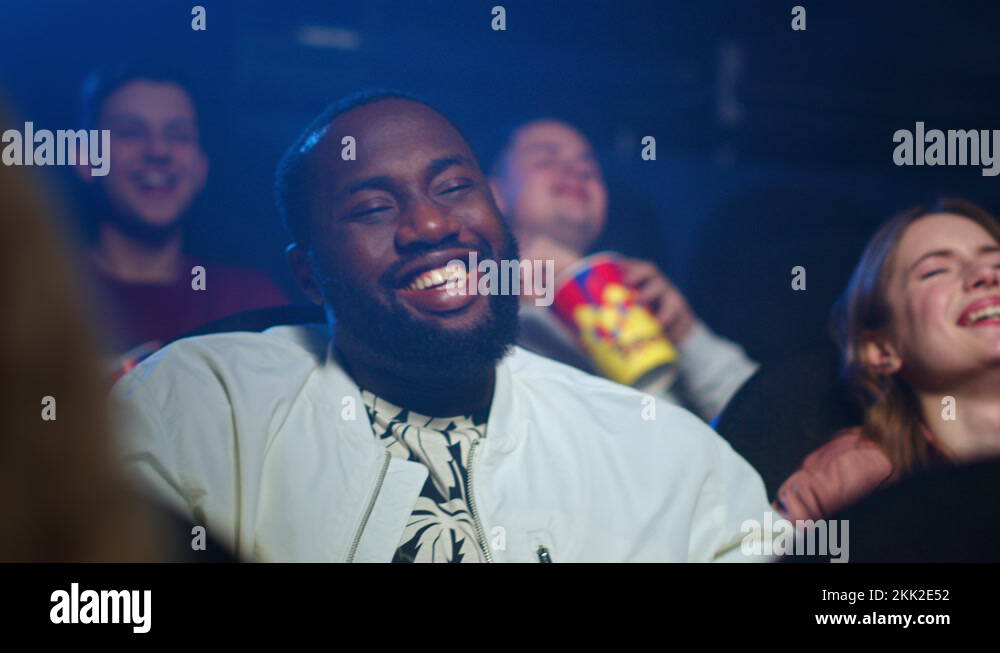 African man eating popcorn in movie theater. Afro guy laughing in cinema Stock Video Footage - Alamy