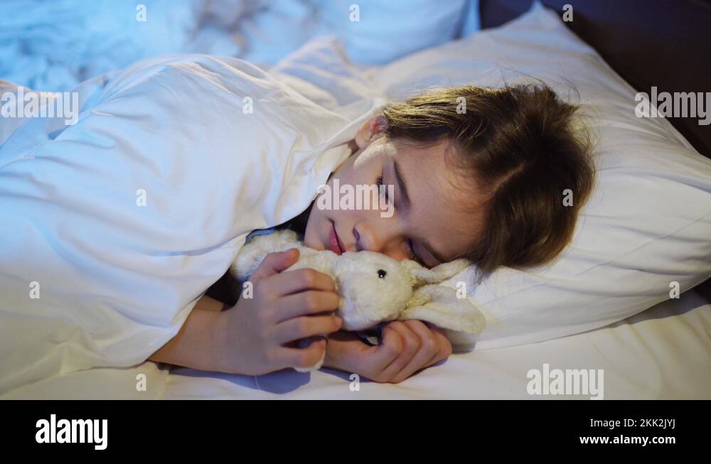 The pretty teenage girl naps with a plush toy, sees a pleasant sleep ...