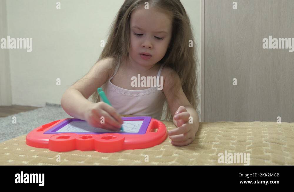 Cute little kid girl artist playing alone drawing coloring picture with ...