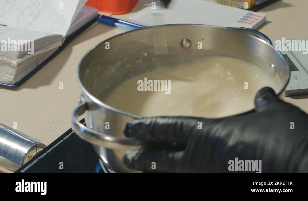 pastry chef prepares custard on the electric stove. He brings the cream ...